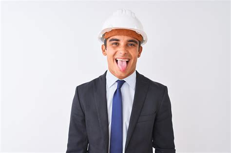 양복과 헬멧을 쓰고 고립된 흰색 배경 위에 혀를 내밀고 재미있는 표정으로 행복한 표정을 짓고 있는 젊은 잘생긴 건축가 남자 감정 개념입니다 감정에 대한 스톡 사진 및 기타