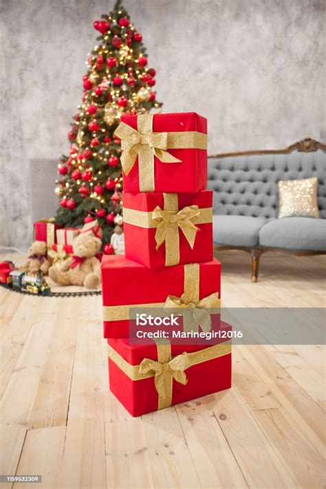 밝은 나무 바닥과 방에 배경에 빨간색과 금 장식 전나무 나무와 서로 서 있는 밝은 빨간 상자의 그룹 새해와 크리스마스 선물 개념