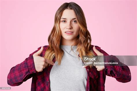 즐거운 미소와 긍정적인 아름 다운 젊은 여자 옷 디자인에 대 한의 빈 복사본 공간에서 나타냅니다 또는 분홍색 Backgroud 이상의 절연 콘텐츠 광고 의류 개념입니다 수평