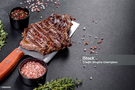 어두운 콘크리트 배경에 향신료와 허브를 곁들인 맛있는 육즙이 많은 신선한 쇠고기 스테이크 0명에 대한 스톡 사진 및 기타 이미지 0명 고기 고추류 Istock