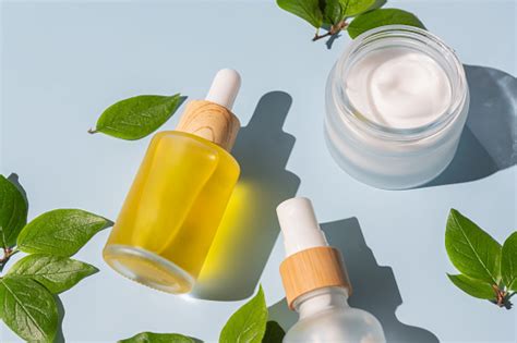 화장품 용기 모형 브랜딩 및 패키징 프레젠테이션을 위한 트렌디한 배경 내츄럴 스킨케어 뷰티 제품 컨셉 혈청 녹색 잎과 하드 섀도우가 있는 에센스와 스프레이 뷰티 세트 0명에