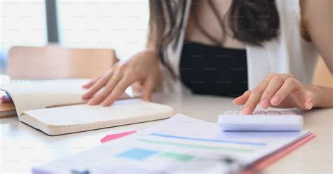 여성 회계사가 재무 데이터를 분석하고 흰색 사무실 책상에서 계산기를 사용하는 장면을 자릅니다 사진 Unsplash의 태국 이미지