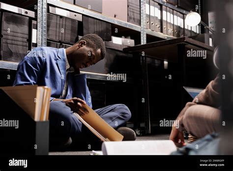 Overworked Private Investigators Discussing Case Evidence Working Late At Night At Criminology