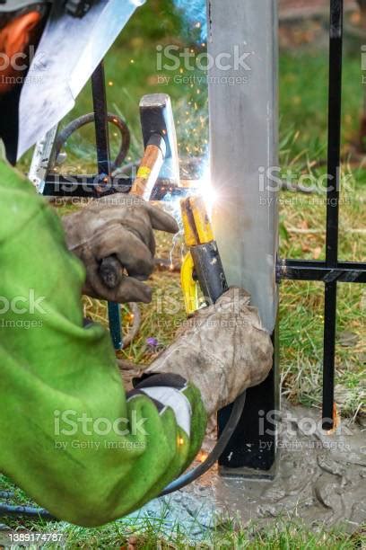 가죽 장갑을 낀 작업자가 금속 울타리를 전기 용접하는 동안 밝은 불꽃과 비행 파란색 연기 Performing Arts Event에 대한 스톡 사진 및 기타 이미지