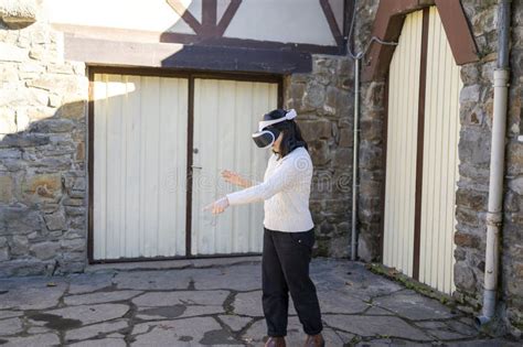 A Young Asian Woman Is Immersed In The World Of Virtual Reality Stock