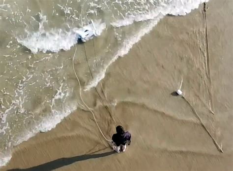 Garbage Collector By Student Scoops Ocean Trash With Waves