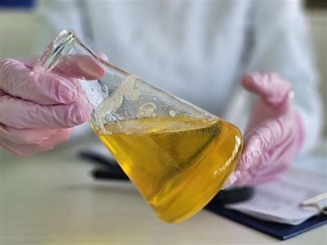 Laboratory Experiment With Yellow Liquid In A Glass Flask Held By A