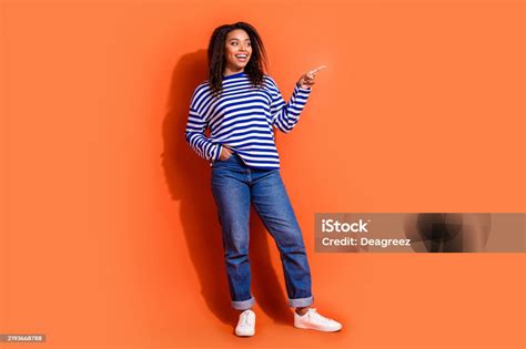 쾌활한 예쁜 아가씨 옷을 입은 줄무늬 셔츠의 전체 길이 사진 손가락 빈 공간 고립 된 오렌지 색 배경을 보여줍니다 25 29세에 대한 스톡 사진 및 기타 이미지 Istock