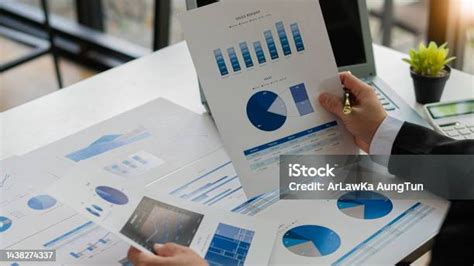 노트북 컴퓨터 및 문서에서 일하는 사무실에서 진지한 사업가 종이 그래프 보고서 차트를보고 최신 랩톱 컴퓨터로 그래프를 분석합니다 취업 면접에 대한 스톡 사진 및 기타 이미지