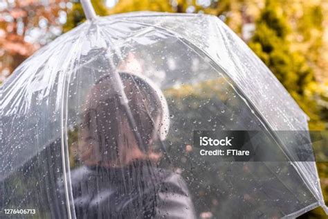 가 공원 정원에서 걷는 헤드폰에 외로운 슬픈 여자 비가 내리는 젖은 투명 우산을 통해 볼 수 있습니다 비오는 날 풍경 빈티지 톤 35 39세에 대한 스톡 사진 및 기타