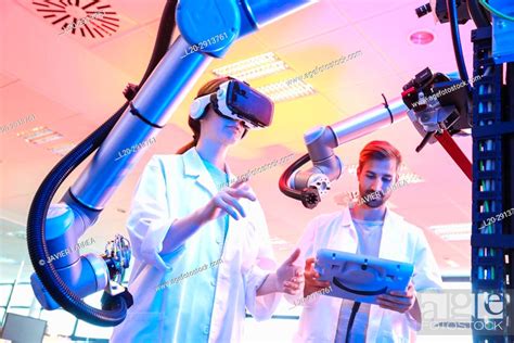 Robotic Arm With Artificial Vision Researcher With Virtual Reality Glasses VR Stock Photo