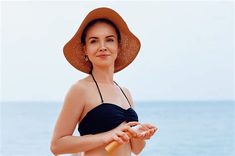 손에 선크림 병을 들고 있는 한 여성 스킨케어 자외선 차단 선스크린 자외선 노출 건강한 생활방식에 대한 스톡 사진 및 기타 이미지 건강한 생활방식 립밤 모자 모자류