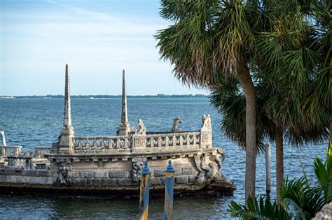 조용한 해안선 근처의 밝은 하늘을 배경으로 첨탑과 야자수가 있는 물 위의 오래된 석조 건축물 0명에 대한 스톡 사진 및 기타 이미지 Istock