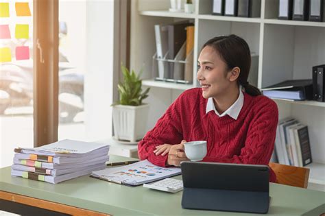 마케팅 재무 회계 기획 여성 회계사가 커피 잔을 들고 노트북 컴퓨터를 사용하고 회사 분석에서 문서 차트 그래프는 이익입니다