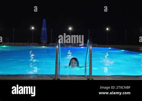 Sexy Body Young Woman In Swimsuit Comes Out Of Colored Water Holding To