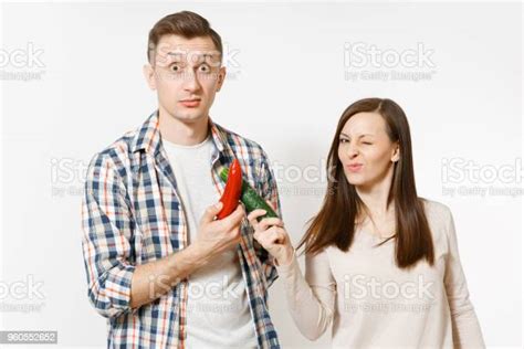 커플 남자 녹색 신선한 오이 흰색 배경에 고립 된 레드 핫 칠리 페 퍼와 싸우는 여자 적절 한 영양 섭취 채식 음식 개념