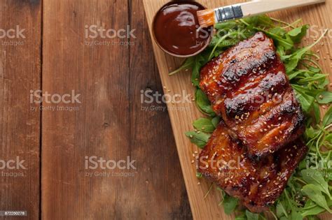 돼지 갈비 바베 큐 소스 구이 Arugula의 침대에 꿀에 Caramelized 오래 된 나무 배경에 제출 나무 보드에 맥주에 맛 있는 간식 복사 공간 평면도 0명에 대한