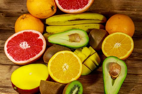 나무 테이블에 열대 과일의 구색 바나나 망고 오렌지 아보카도 자몽 키위 과일을 곁들인 정물 감귤류 과일에 대한 스톡 사진 및 기타 이미지 Istock