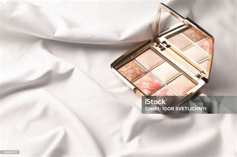 고급 아이섀도우 팔레트 화이트 실크 천에 아이 섀도우 화장품 제품 섬세한 직물에 직물 배경 커튼과 주름 공간을 복사합니다 Mua