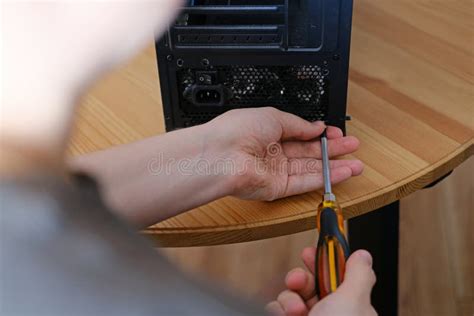 A Man Disassembles A Computer System Unit With A Screwdriver Stock Image Image Of Notebook