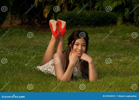 Smilling Pretty Asian Woman Pose Of Lying On A Lawn In The Park Stock
