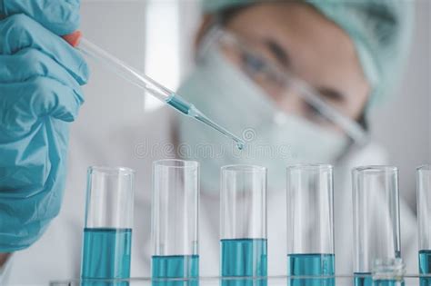 Female Researchers Are Experimenting With Pipette Dropping A Sample Into A Test Tube In An