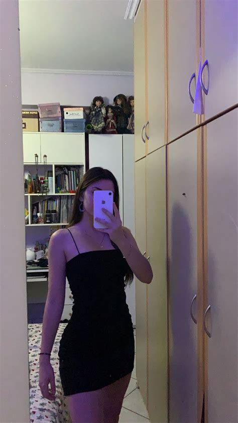 A Woman Is Taking A Selfie In The Mirror With Her Cell Phone While