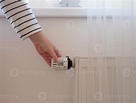 Woman Regulates Temperature At Home With The Heating Thermostat To Save Energy Close Up With