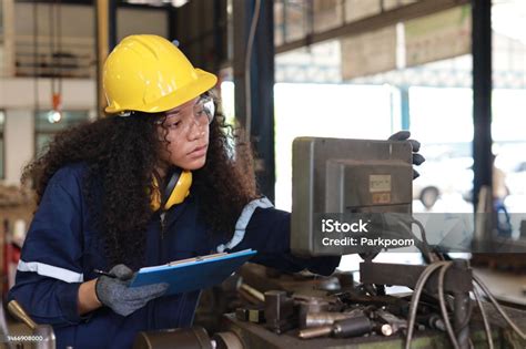 안전 안전모 유지 보수 작업을 하거나 중공업 제조 공장에서 선반 금속 기계를 확인하는 보호 유니폼을 입은 기술자 엔지니어 또는