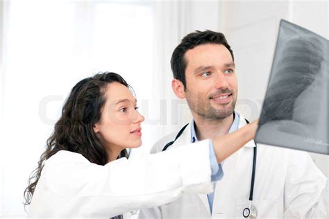 View Of A Young Doctor And Nurse Analysing Radiography Colourbox