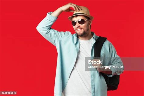 모자를 쓴 남자 관광객의 초상화와 빨간 배경에 어깨에 배낭을 대고 있는 사진입니다 개념에 대한 스톡 사진 및 기타 이미지 개념 관광 관광객 Istock