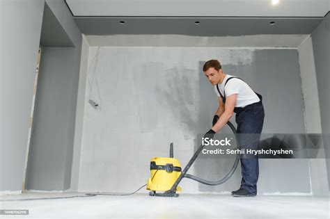 작업자가 바닥을 수리한 후 방을 청소합니다 진공 청소기로 리노베이션 후 아파트 가사 집안일에 대한 스톡 사진 및 기타 이미지