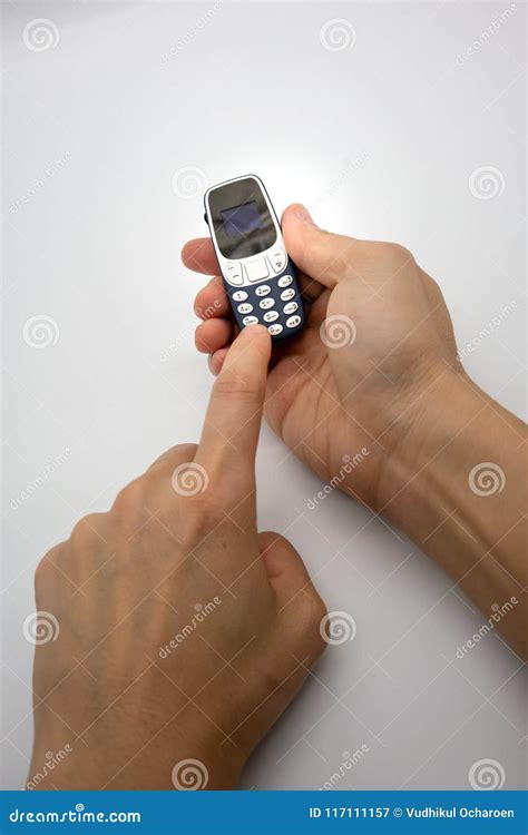 Woman Hand Holding The World Smallest Mobile Phone With Oled Screen In Blue Plastic Body