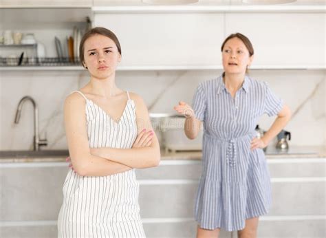 Offended Young Girl Standing In The Kitchen Angry Mother Talking Stock