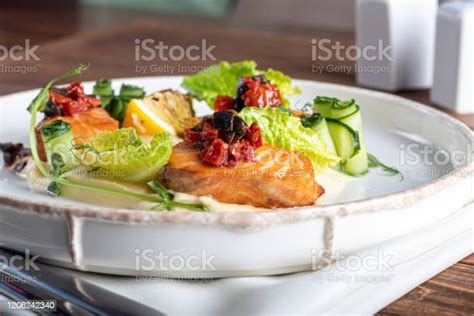 셀러리와 감자 퓌레에 붉은 생선 조각을 더하고 허브와 신선한 오이로 장식합니다 레몬 슬라이스와 흰색 접시에 나무 테이블에 0명에 대한 스톡 사진 및 기타 이미지 Istock