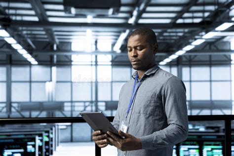 Engineer In Data Center With Tablet Automating Routine Maintenance Tasks Stock Image Image Of