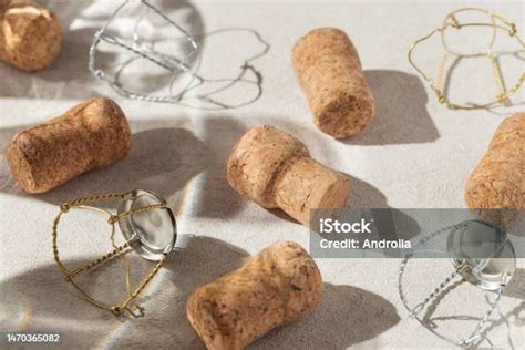 그림자가 있는 베이지색 햇볕이 잘 드는 배경에 샴페인 코르크로 만든 창의적인 구성 스파클링 와인과 금속 와이어 뮤즐렛으로 만든 병 뚜껑 여름 파티 음료 컨셉 샴페인 마개에