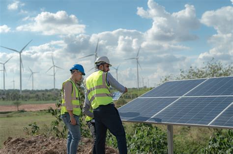 엔지니어 는 전자 장치로 태양 전지 패널 또는 태양광 전지의 건설을 검사합니다 녹색 전력의 산업 재생 에너지 타워 지붕에서 일하는 공장 노동자 3 명에 대한 스톡 사진 및