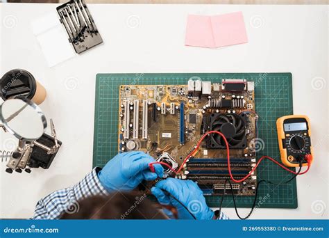 Computer Engineer Working On An Old Motherboard Testing It With Multimeter Electronic