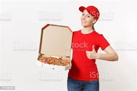 흰색 배경에 고립 된 빨간 유니폼에 배달 여자 꽤 여성 모자 티셔츠 청바지 택배 또는 골 판지 Flatbox에서 이탈리아 피자를 들고 딜러로 일하고 광고에 대 한 공간을