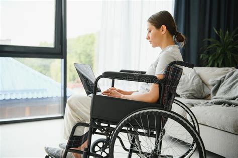 Female Freelance Programmer Sitting In Wheelchair And Using Computers While Coding Web Game At