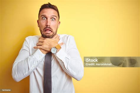 노란색 고립 된 배경 에 우아한 흰색 셔츠를 입고 젊은 잘 생긴 사업가 는 고통스러운 목졸림 때문에 외치고 질식 건강 문제 질식