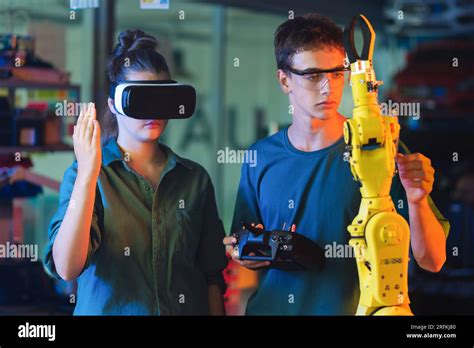 Teens Doing Experiments In Robotics In A Laboratory Boy In Protective