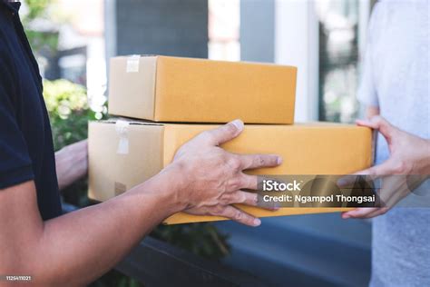 소포 상자를 수락 하는 받는 사람 젊은 소유자에 게 배달 메일 남자 게시물 선적에서 골 판지 상자 패키지의 홈 택배 및 배달 서비스 마음 개념 교통수단에 대한 스톡 사진 및