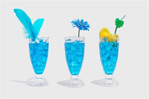알코올 육즙이 많은 과일 블루 칵테일과 큐라소 주류 레몬 슬라이스 얼음 조각 깃털 꽃 및 마시는 빨대 여름 음료 파티 장면 트렌디 한 미니멀리스트 음료 구성 0명에 대한