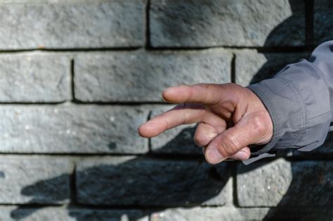 승리의 손 기호입니다 제스처 두 손가락의 남자 손 긍정적 평화 승리 개념 회색 돌 벽 배경에 근접 촬영 보기 복사 공간이 있는 최소 구성 굴리기에 대한 스톡 사진 및 기타