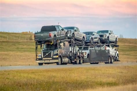 A Large Car Carrier Truck Transports A Variety Of Vehicles Trucks On A