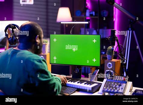 Musician Operates On Midi Controller Piano Keys Next To Mockup Screen Producing New Songs With