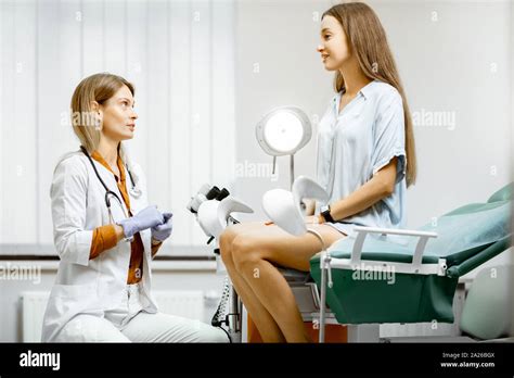 Gynecologist Preparing For An Examination Procedure For A Pregnant Woman Sitting On A