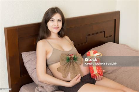 크리스마스 장식과 집에서 잠옷에 귀여운 행복 임산부 어머니는 큰 배를 가지고 배를 통해 손 메리 크리스마스 휴일 새해 전야 컨셉 25 29세에 대한 스톡 사진 및 기타